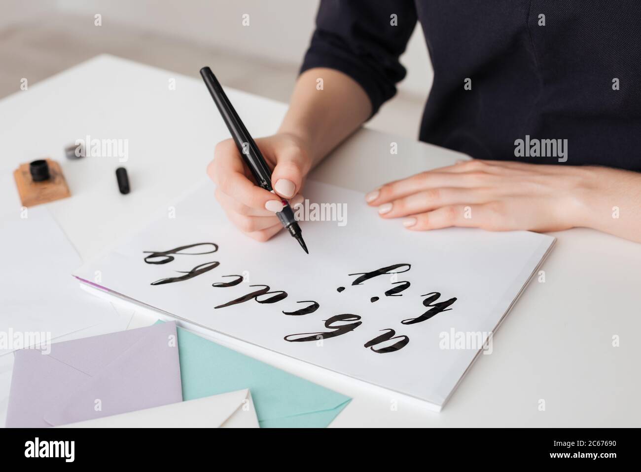 Portrait of young woman hands writing alphabet on paper on desk ...