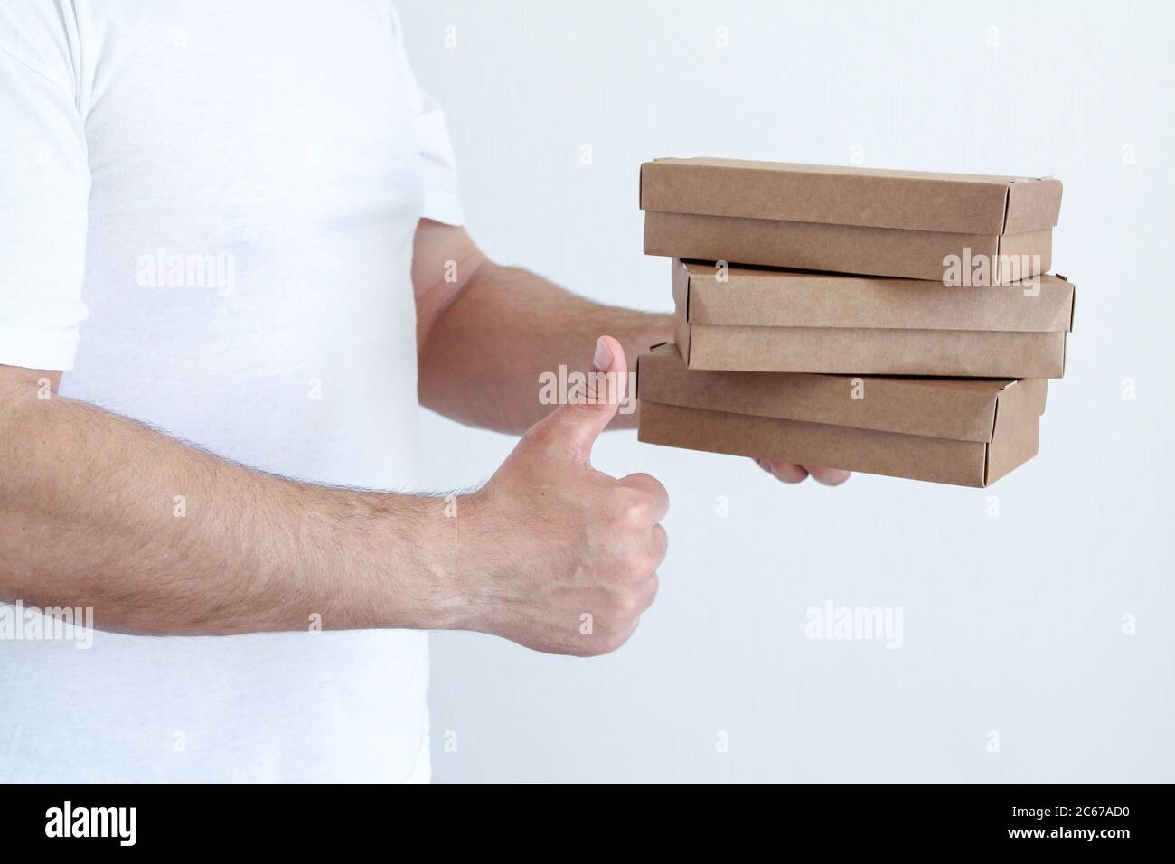 Young man carrying craft eco boxes for shipment. Parcel delivery ...