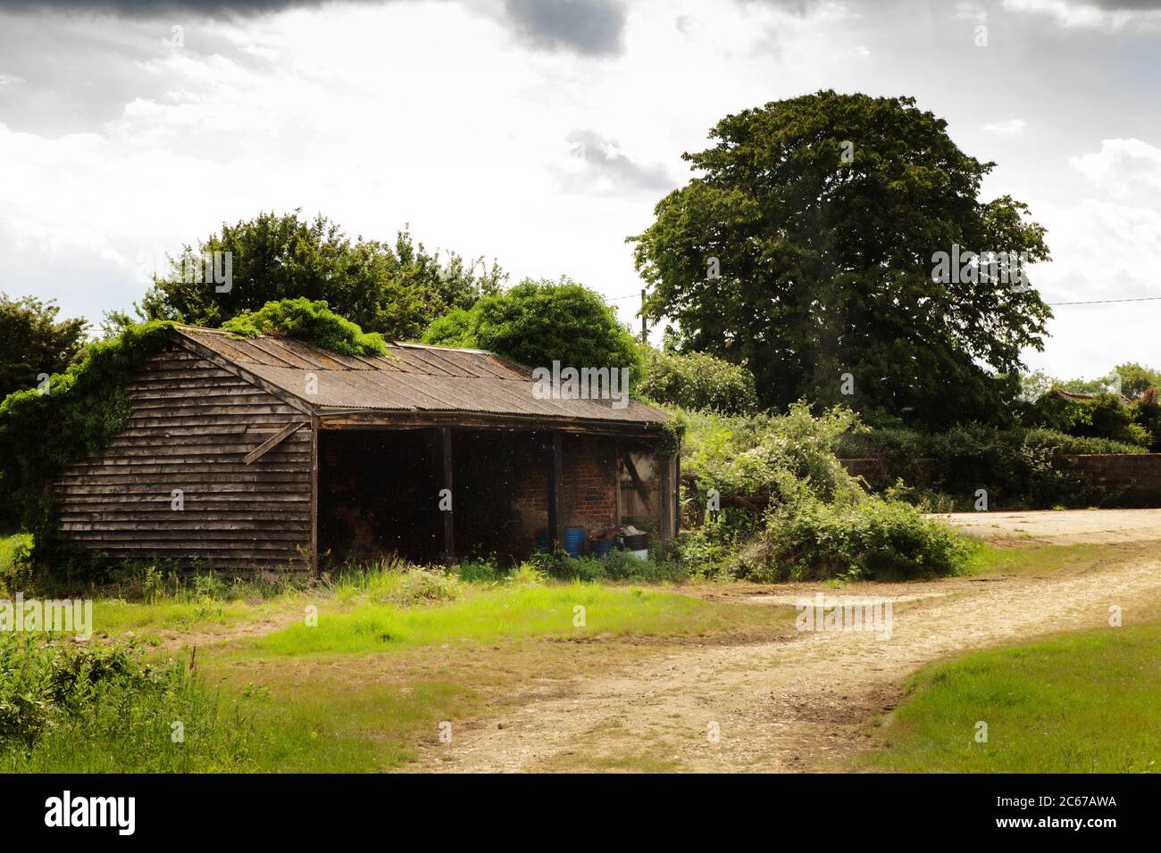 single track pathway along a farmland with an old barn Stock Photo - Alamy