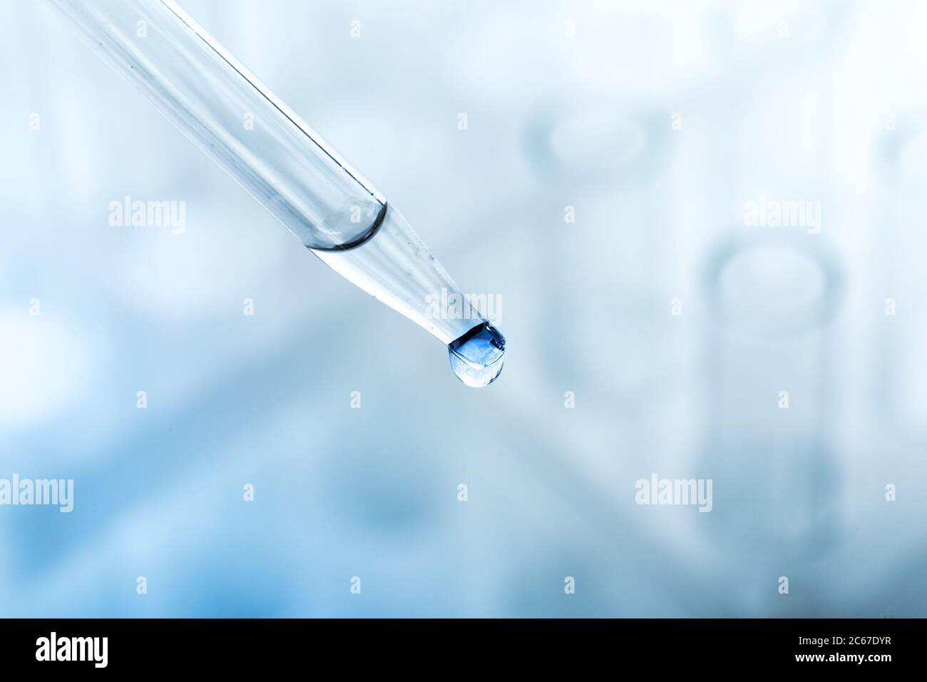 pipette with a drop and scientific laboratory test tubes in a research ...