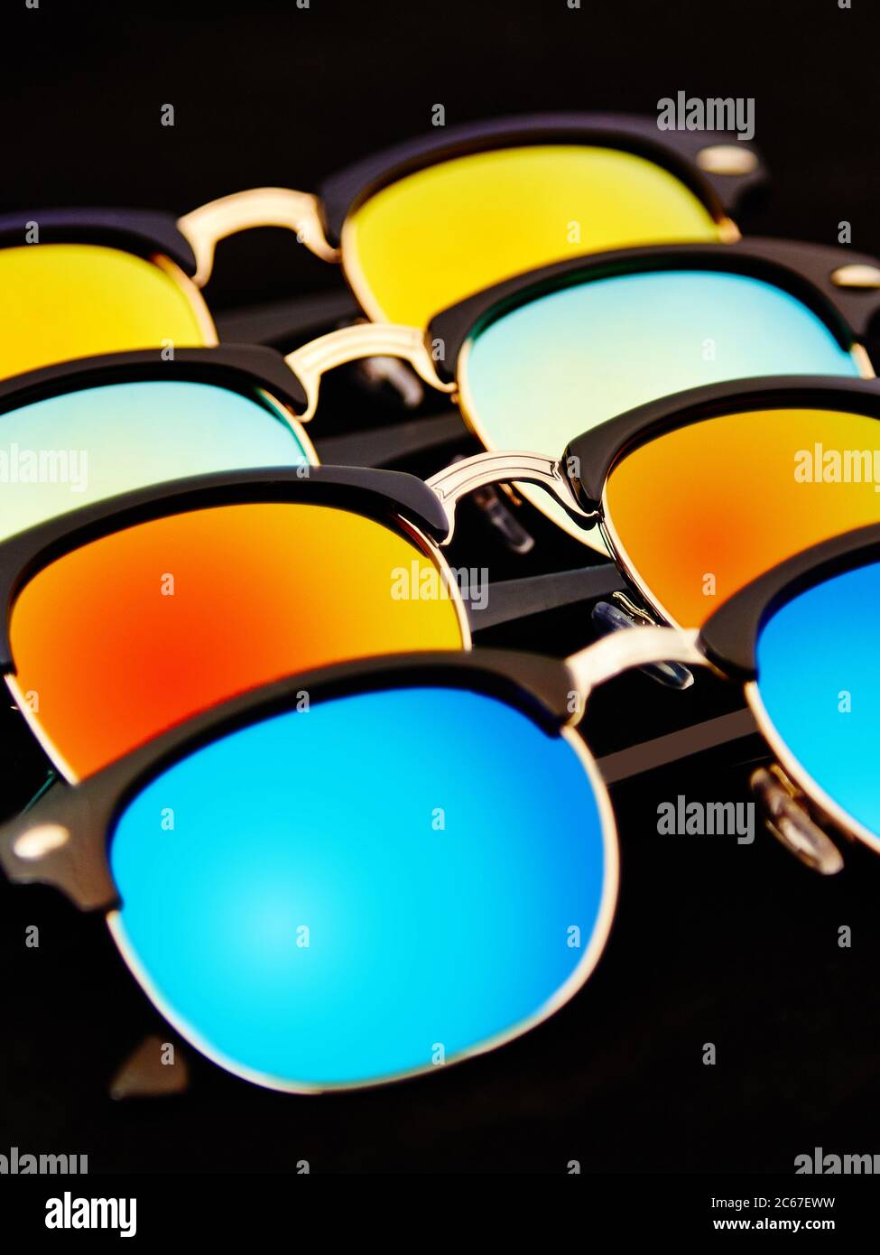 Sunglasses with colorful lenses on black background Stock Photo - Alamy