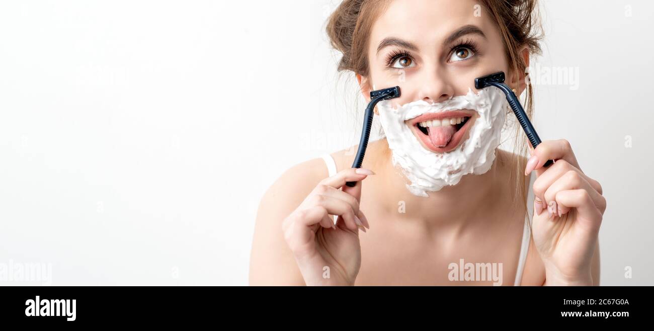 Beautiful young caucasian woman shaving her face by two razors with ...