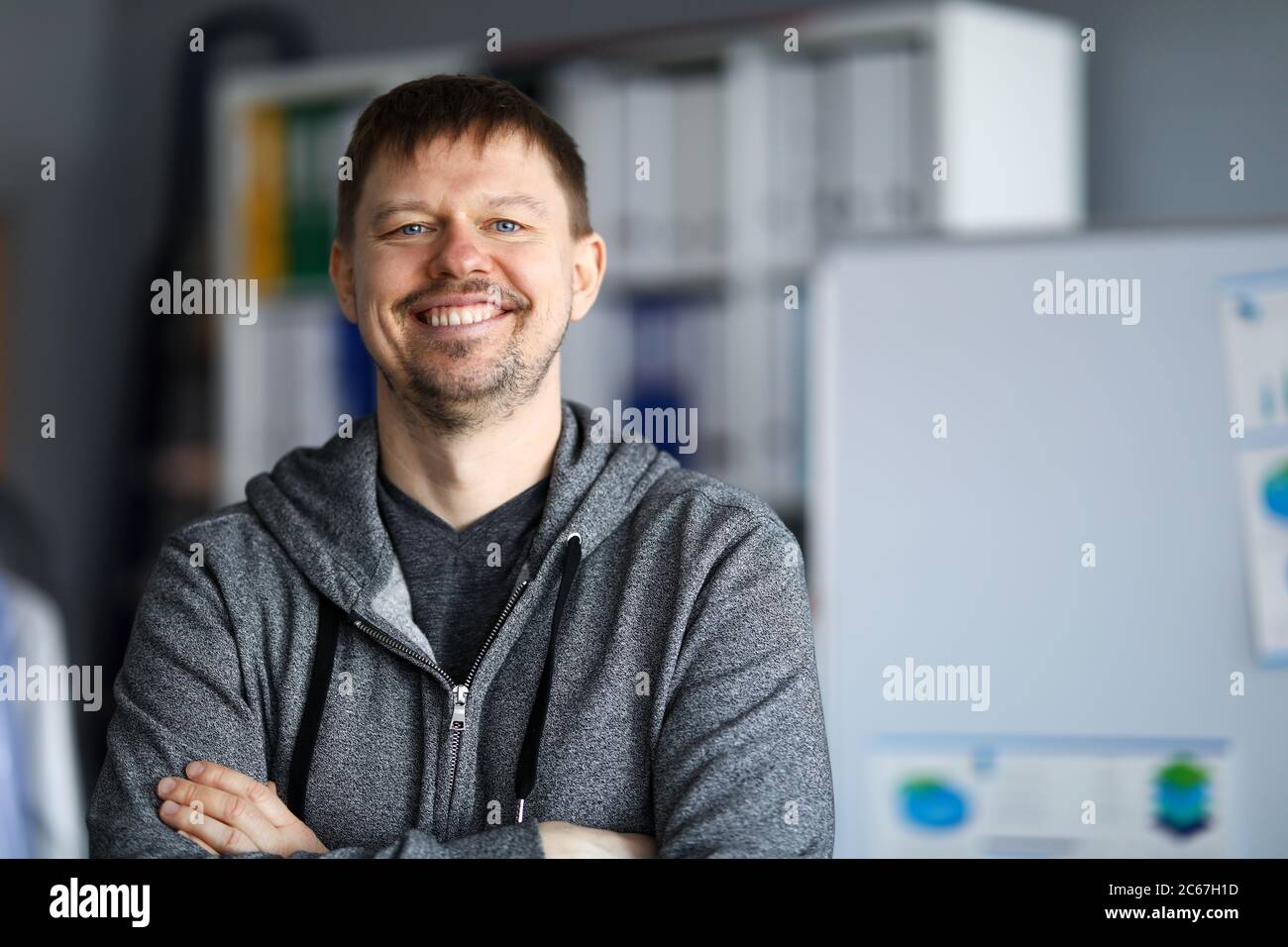 Self-satisfied man is standing in room and smiling Stock Photo - Alamy