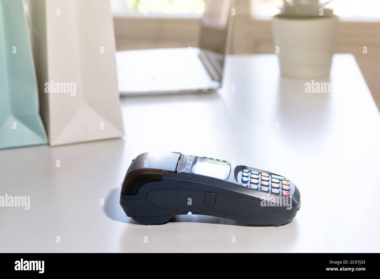 NFC payment terminal on a white table. Credit card or phone pay pos ...