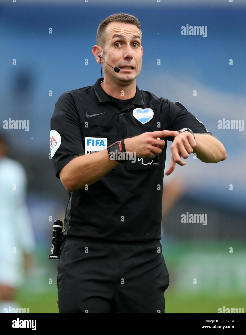Match referee David Coote gestures to his watch during the Premier ...