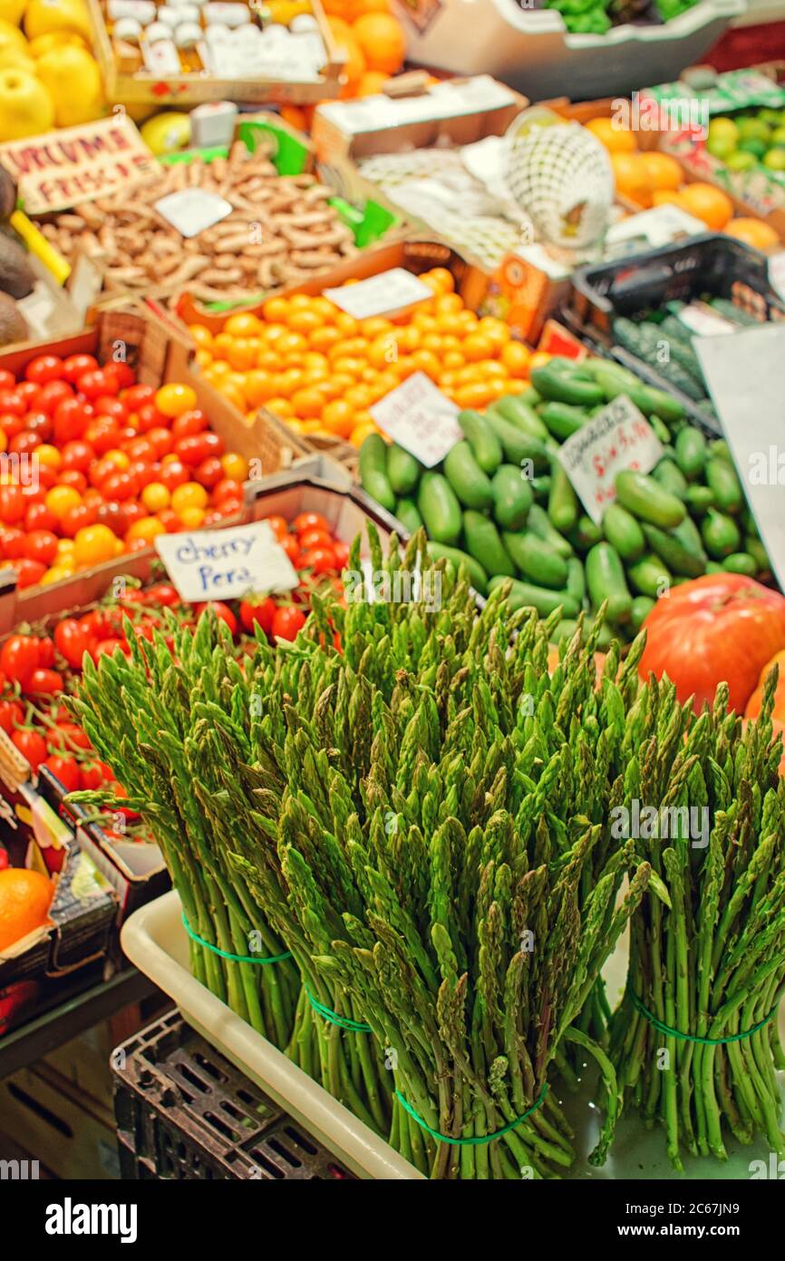 Fresh asparagus and another vegetables on food market display, toned ...