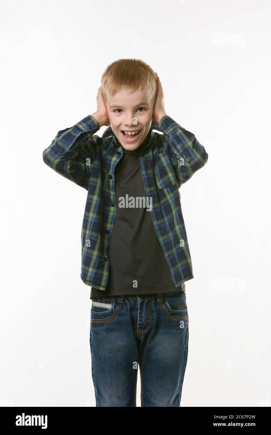 The boy covers his ears with his hands and shouts looking into the ...
