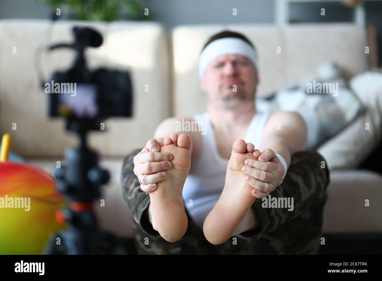 Man holding his feet with his hands Stock Photo - Alamy
