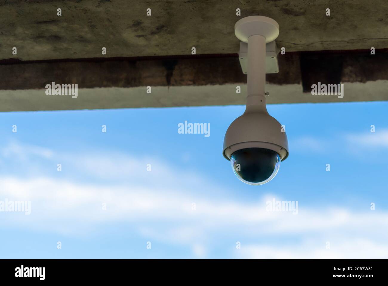 Panoramic security camera hanging on the wall with blue sky background ...