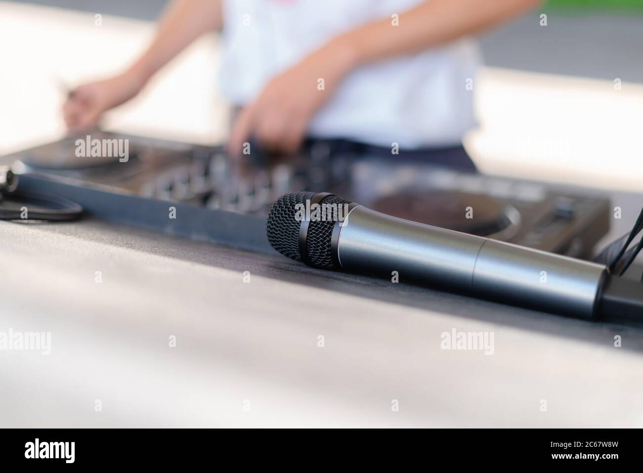 Close up shot of a microphone next to DJ playing music at outdoor event ...
