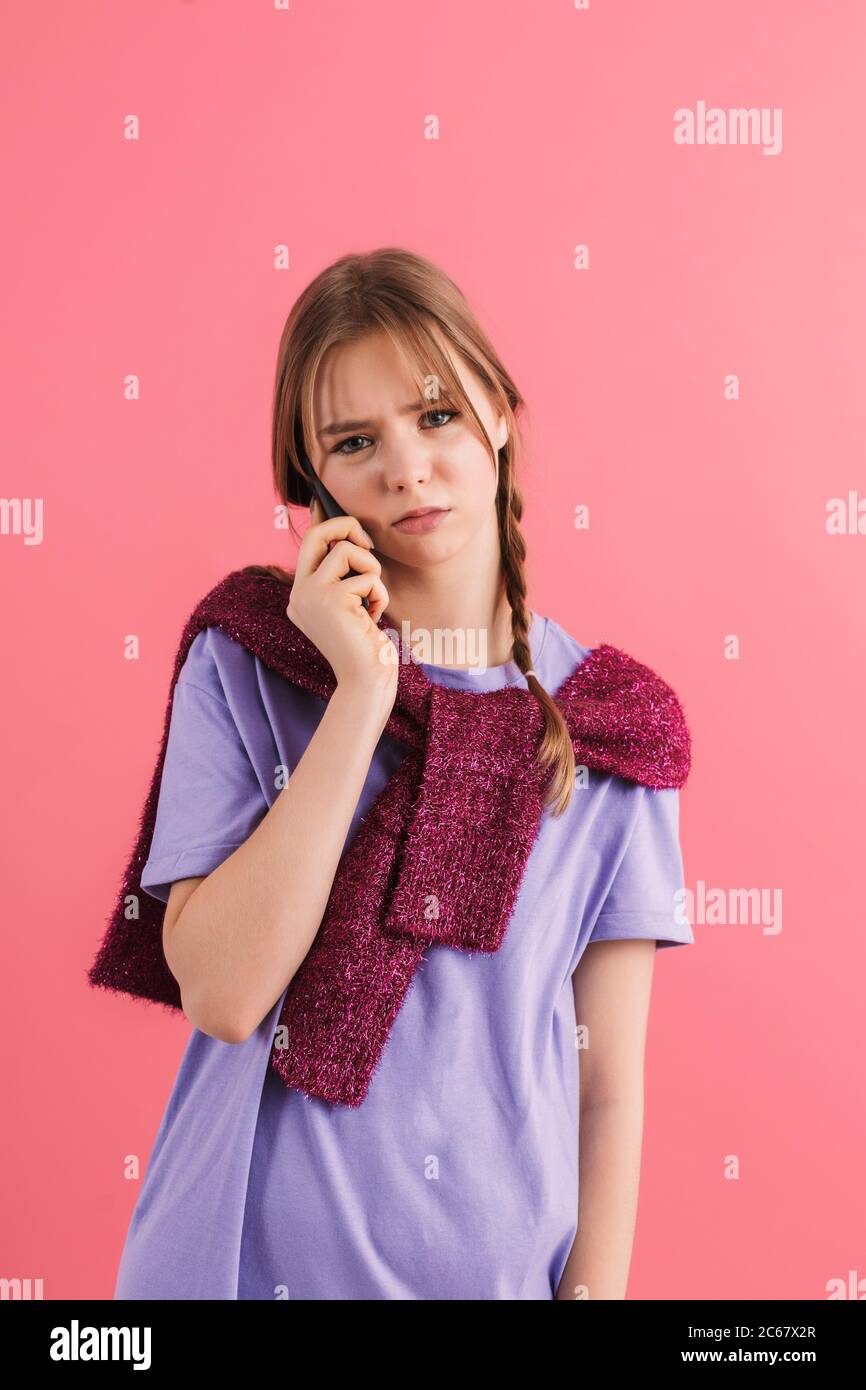 Young upset girl with two braids in lilac t shirt and sweater on ...
