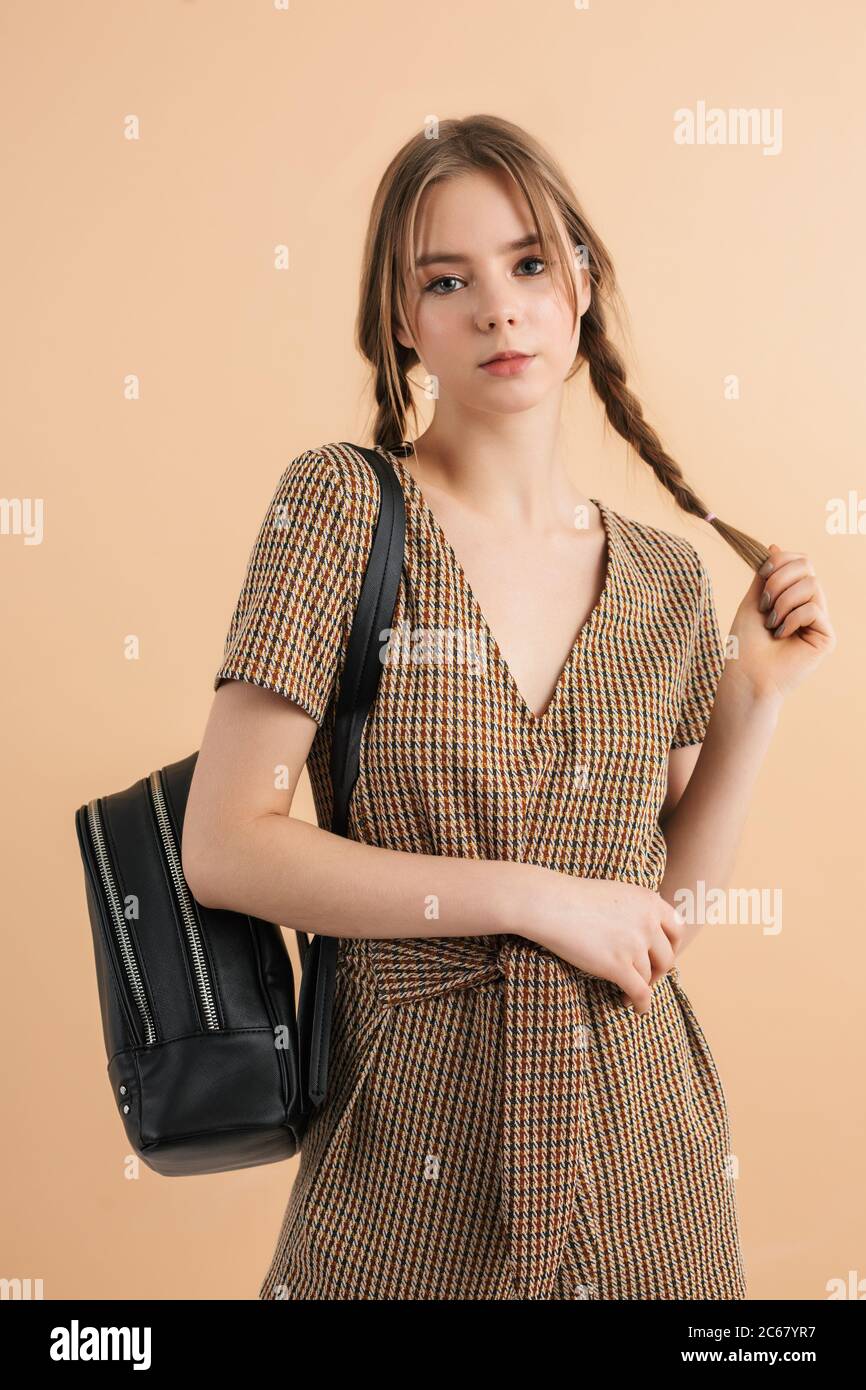 Young beautiful girl with two braids in tweed jumpsuit with black ...