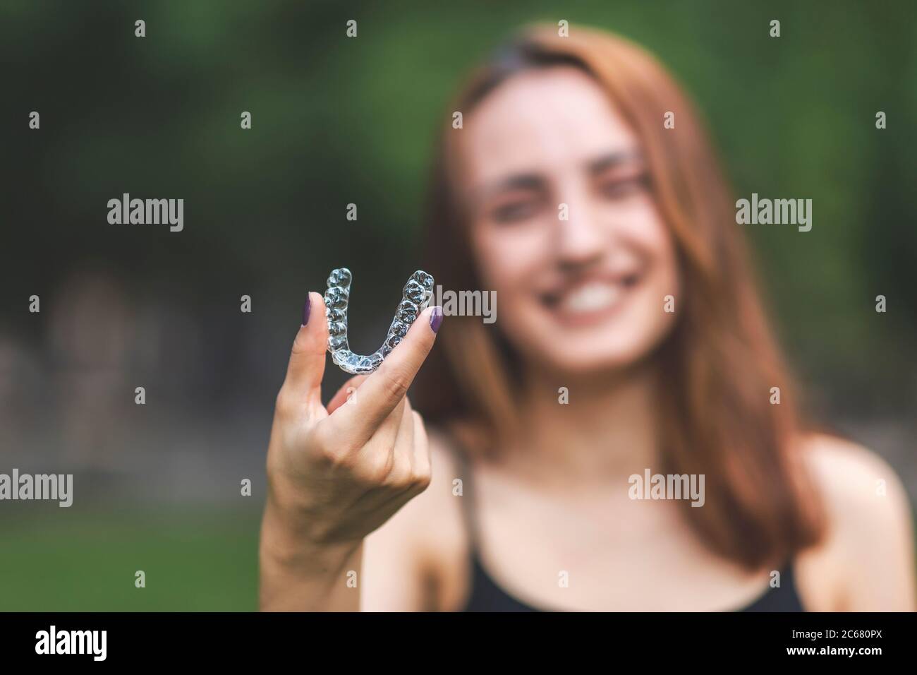 Beautiful smiling Turkish woman is holding an invisalign bracer with ...