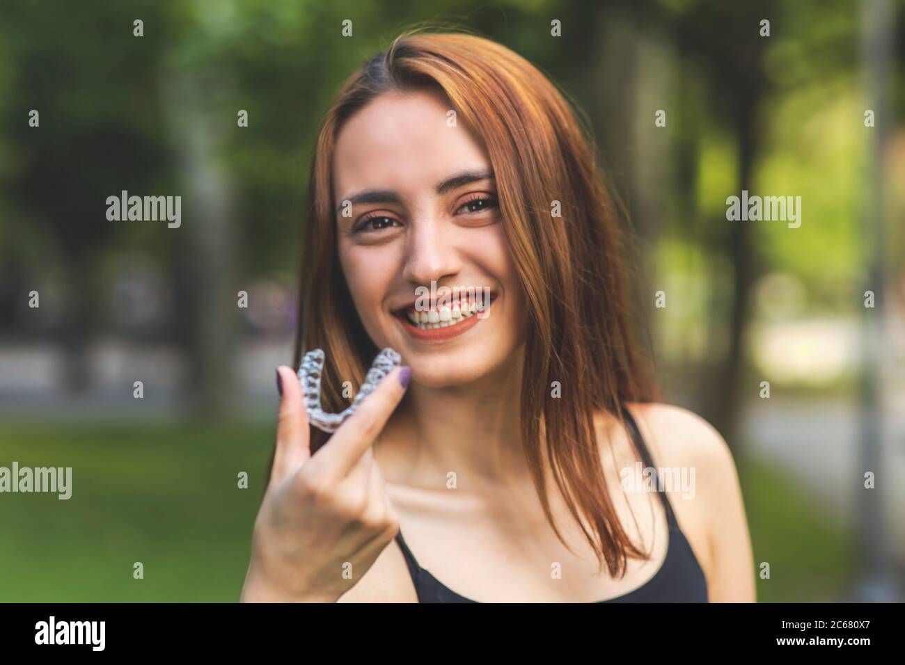 Beautiful smiling Turkish woman is holding an invisalign bracer with ...