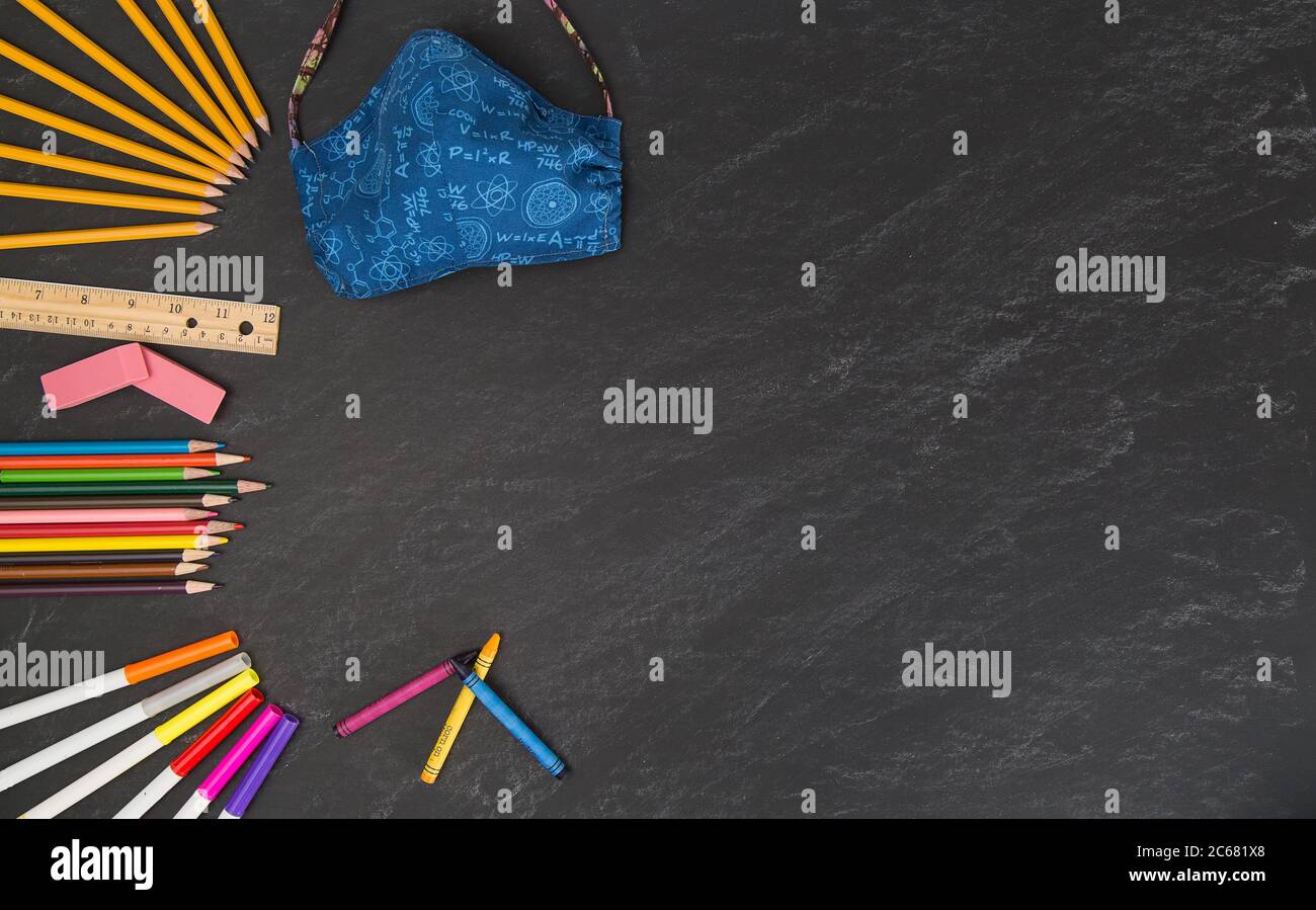 Science theme face mask with back to school supplies on a grey ...