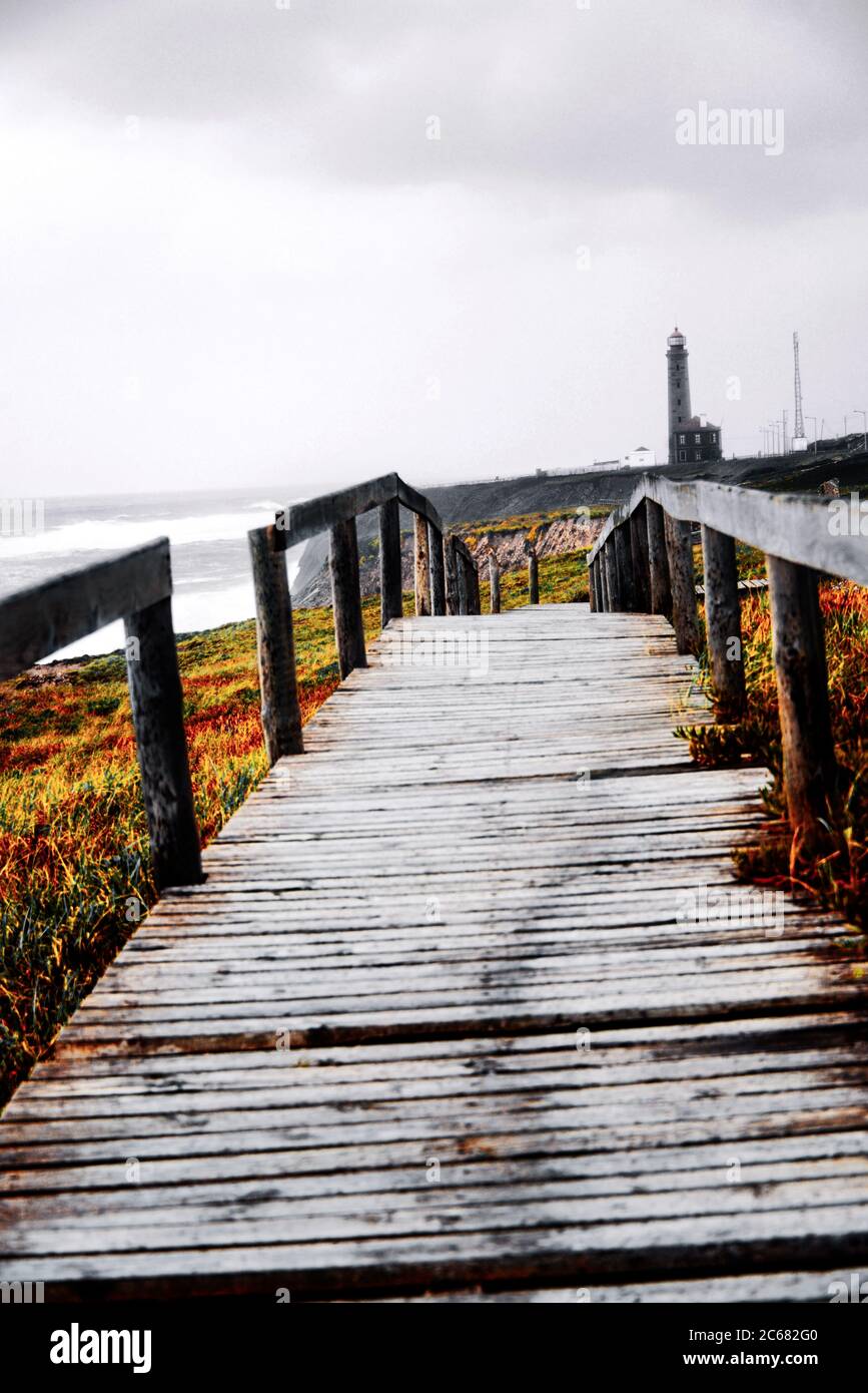 Wooden pedestrian walkway and a lighthouse Stock Photo - Alamy