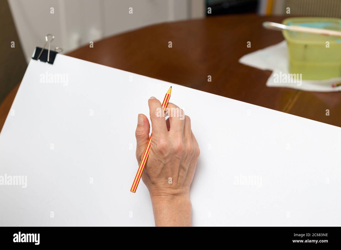 Female hand holding a wooden pencil ready to draw a sketch paint on a ...