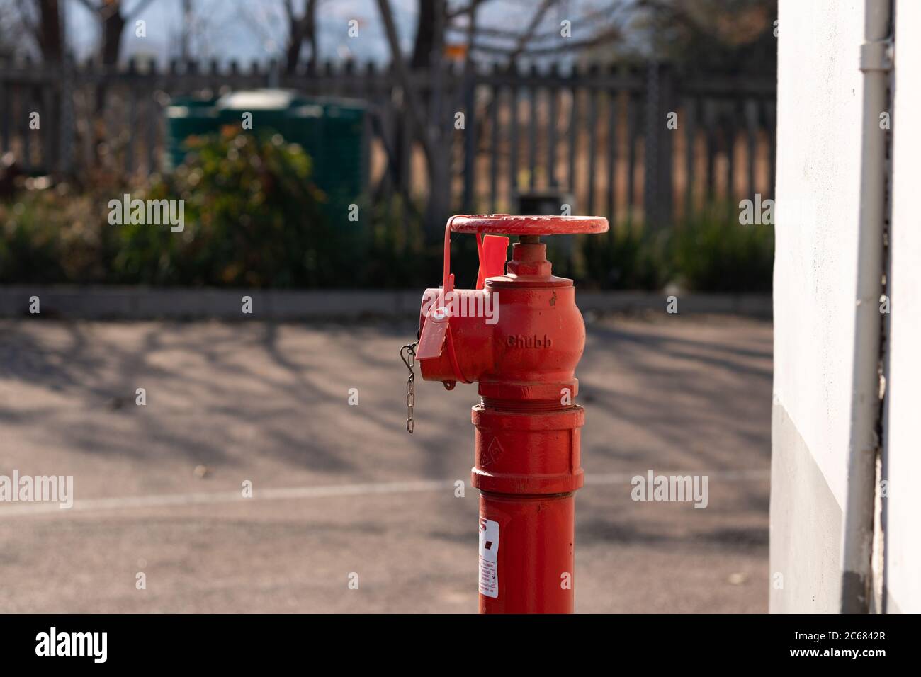Red fire hydrant with a green tank in the background in sunlight Stock ...