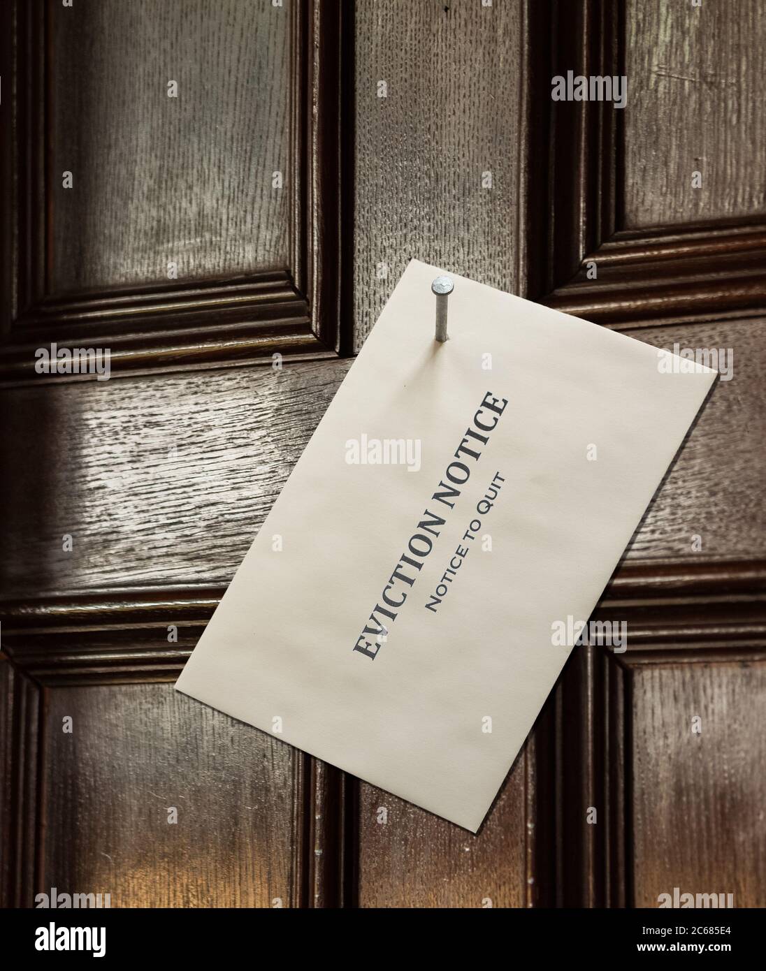 Envelope nailed to an old wooden door with a large nail in containing ...