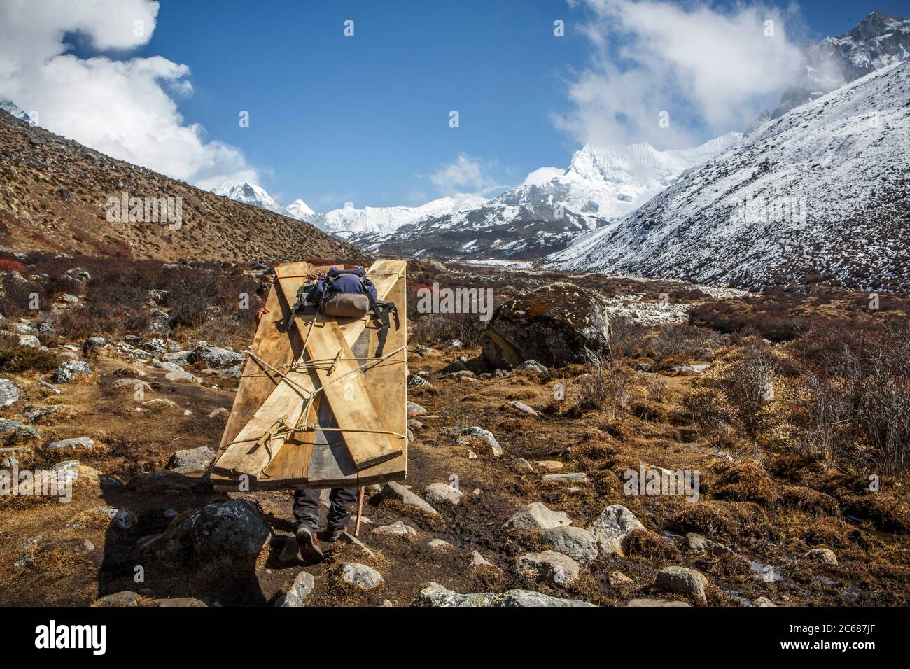 A porter carries wood up the trail towards Everest Base Camp in Nepal ...