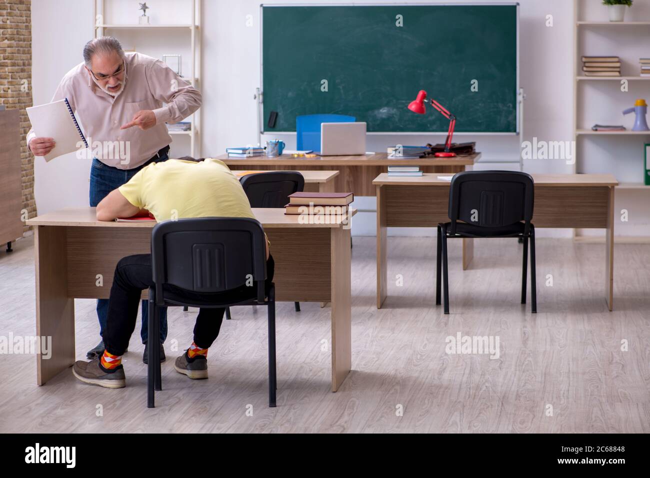 Old teacher and young student in the classroom Stock Photo - Alamy