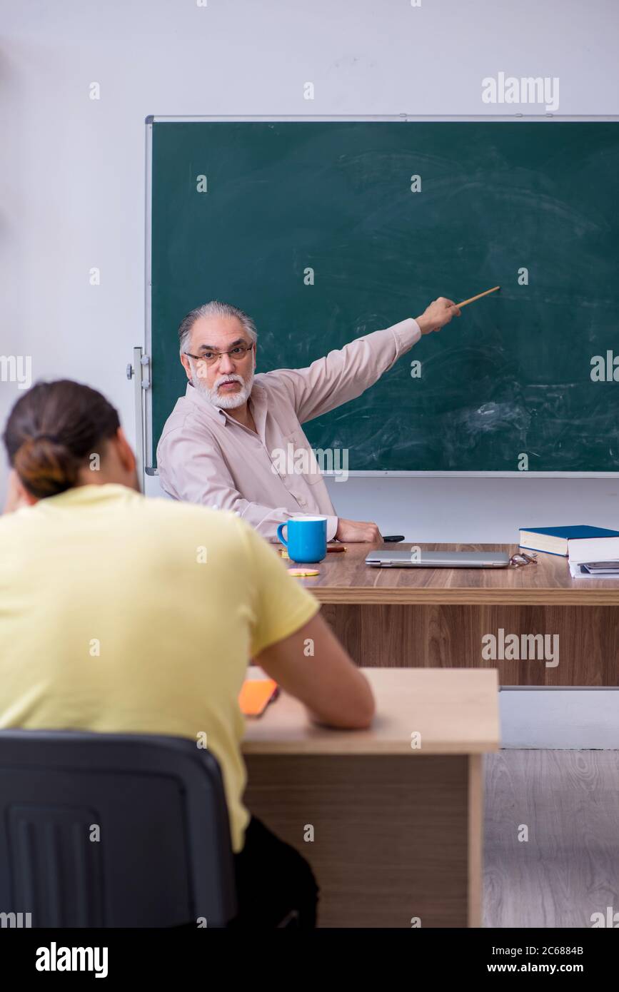 Old teacher and young student in the classroom Stock Photo - Alamy