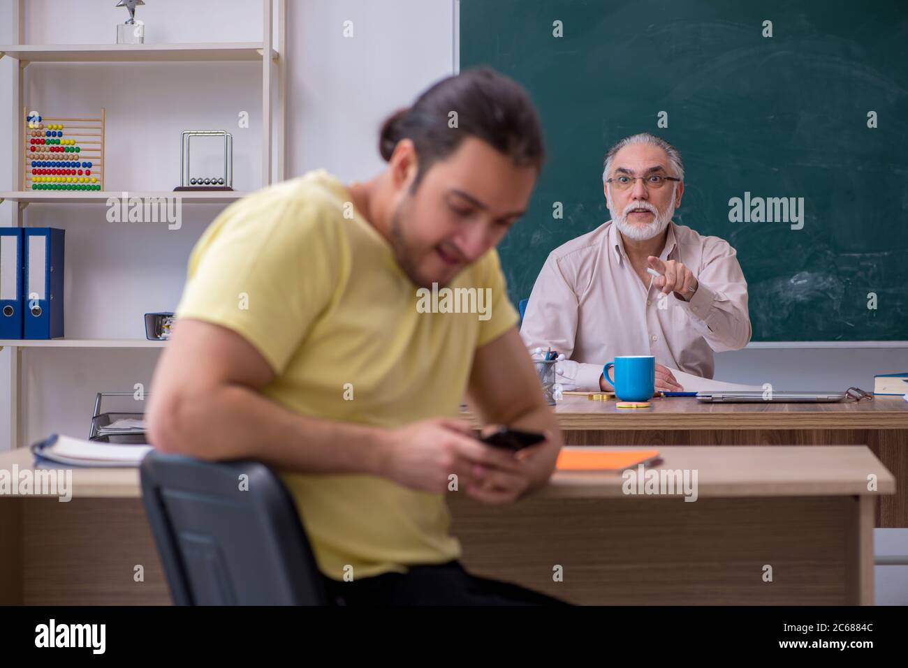 Old teacher and young student in the classroom Stock Photo - Alamy