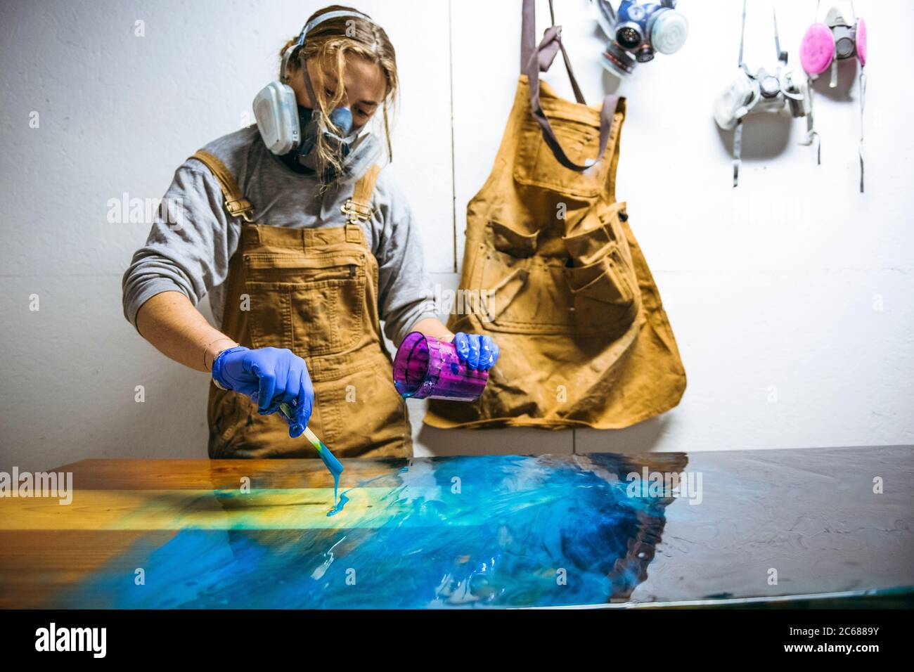 Female resin artist using simple tools to mix resin tint Stock Photo ...