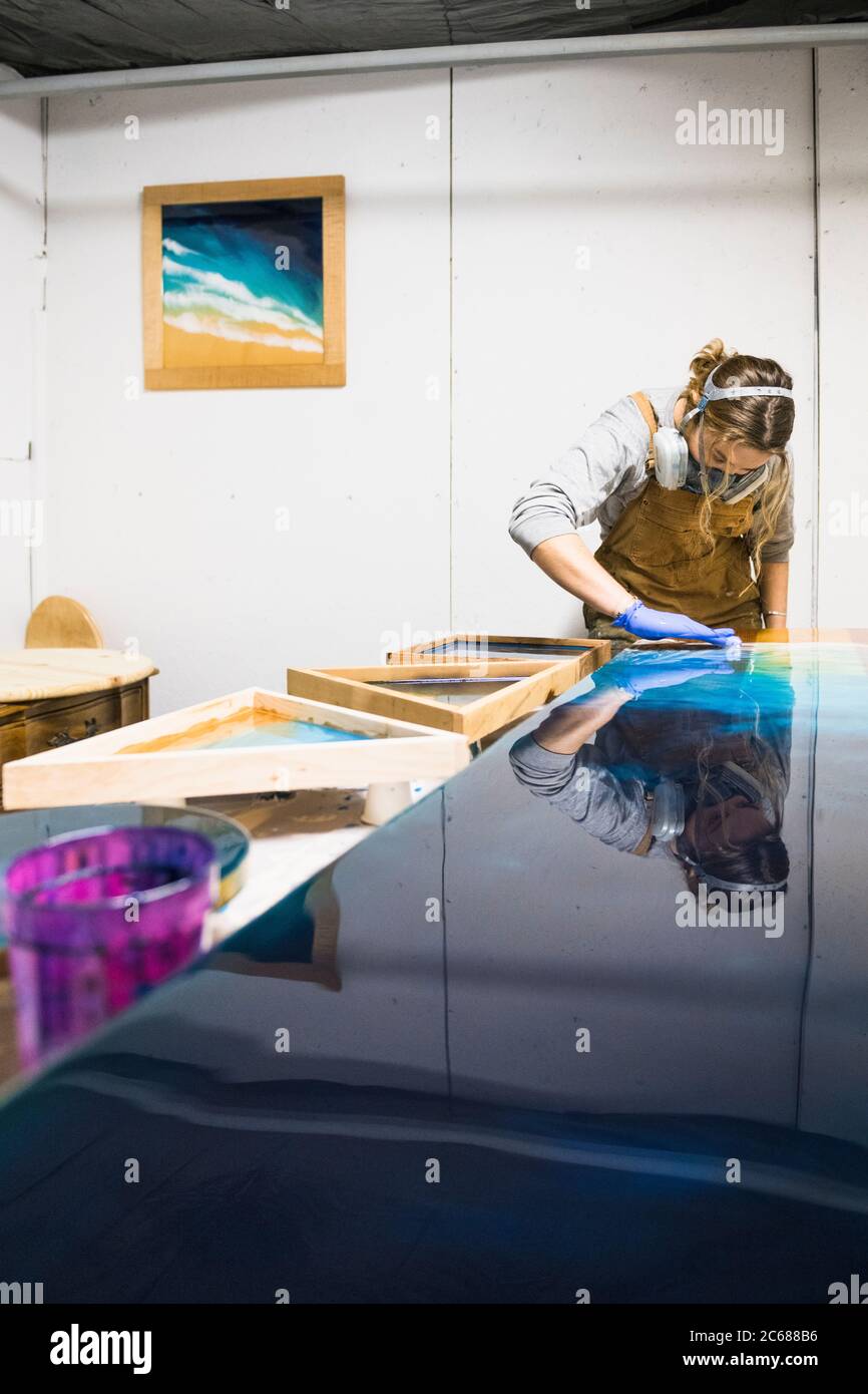Female resin artist using hands to perfect artwork Stock Photo - Alamy