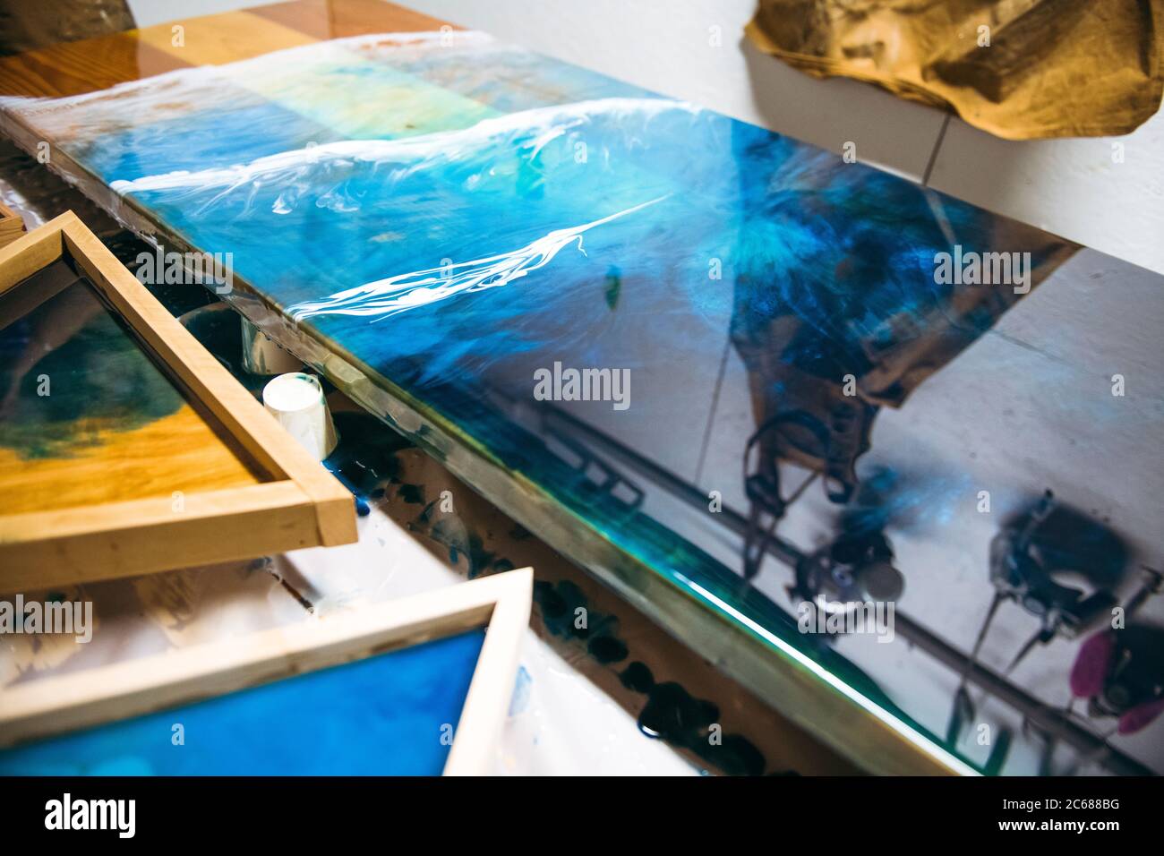 Detail of reflective resin artwork drying in art studio Stock Photo - Alamy