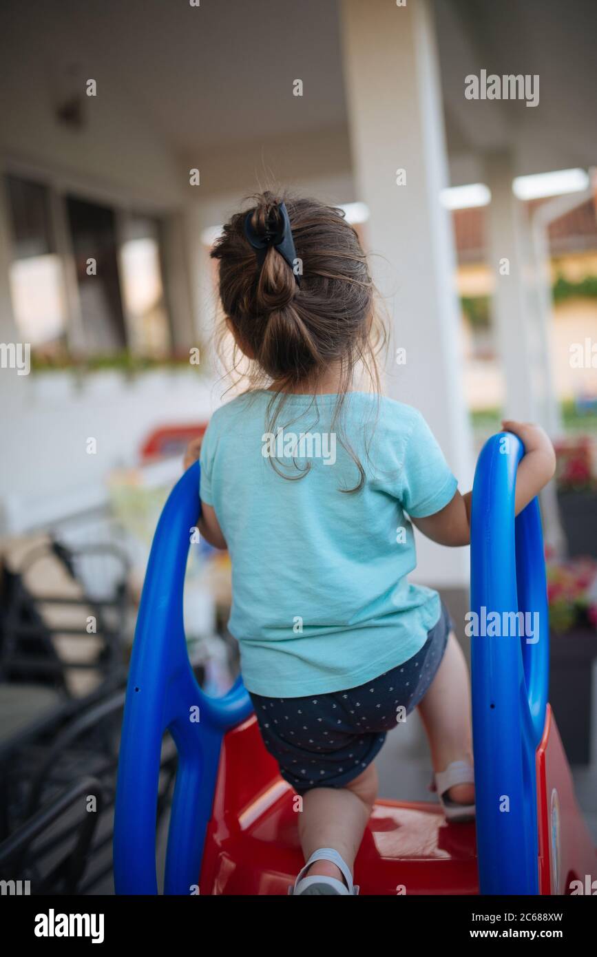 Little girl on a slide. Back view Stock Photo - Alamy