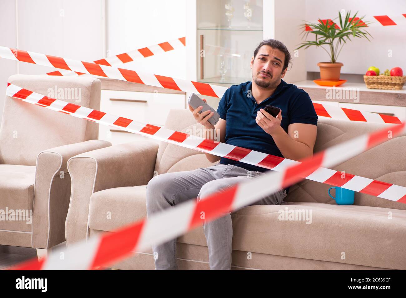 Young man feeling bored at the home in self-isolation concept Stock ...