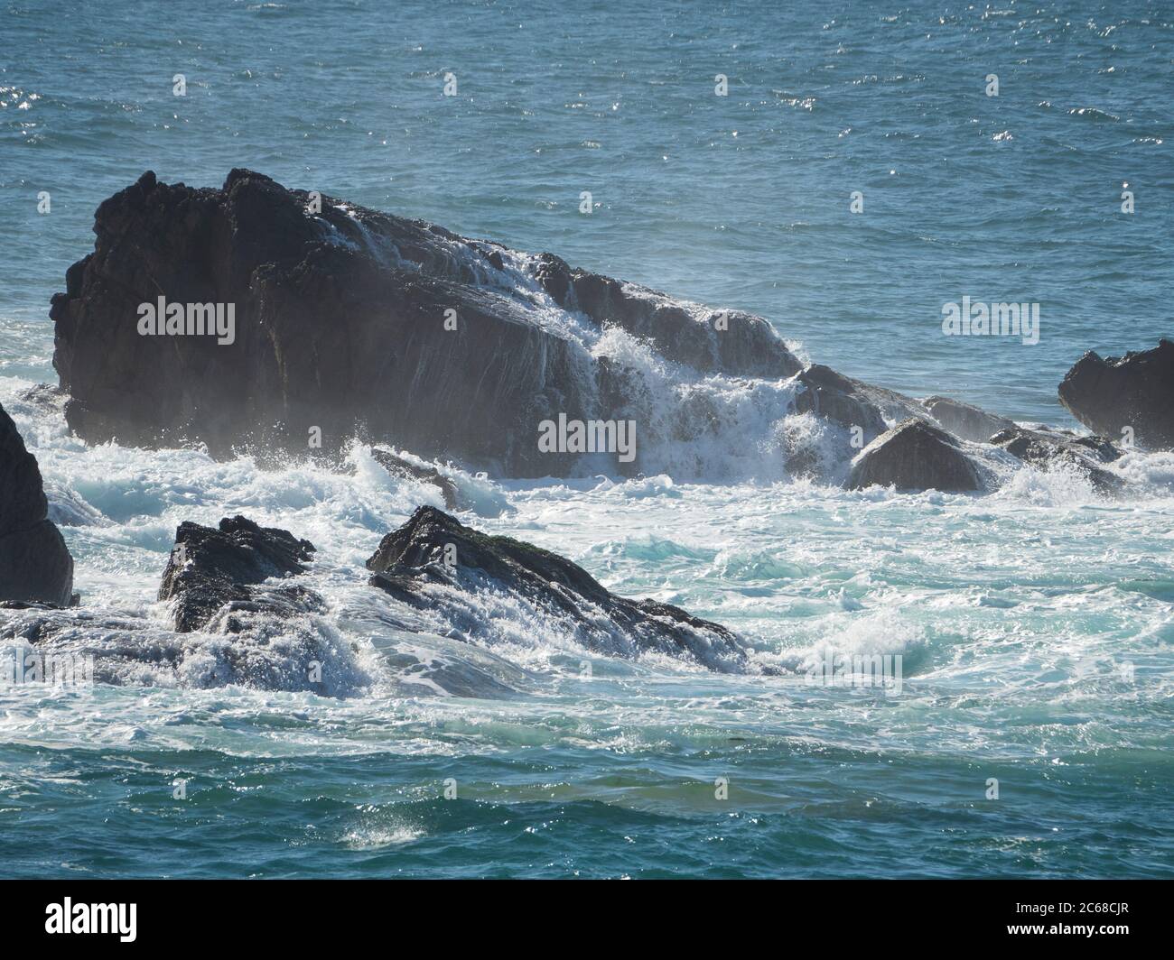 Water running down rocks after waves crashing over rocks near the shore ...