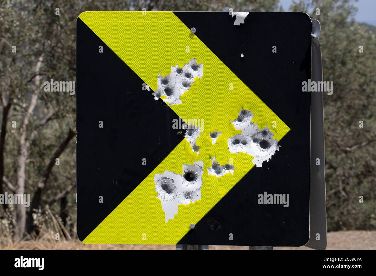Red road traffic sign full of bullet holes. Close up Stock Photo - Alamy