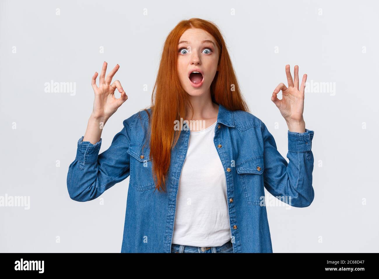 Amused, excited and thrilled good-looking redhead female in denim shirt ...
