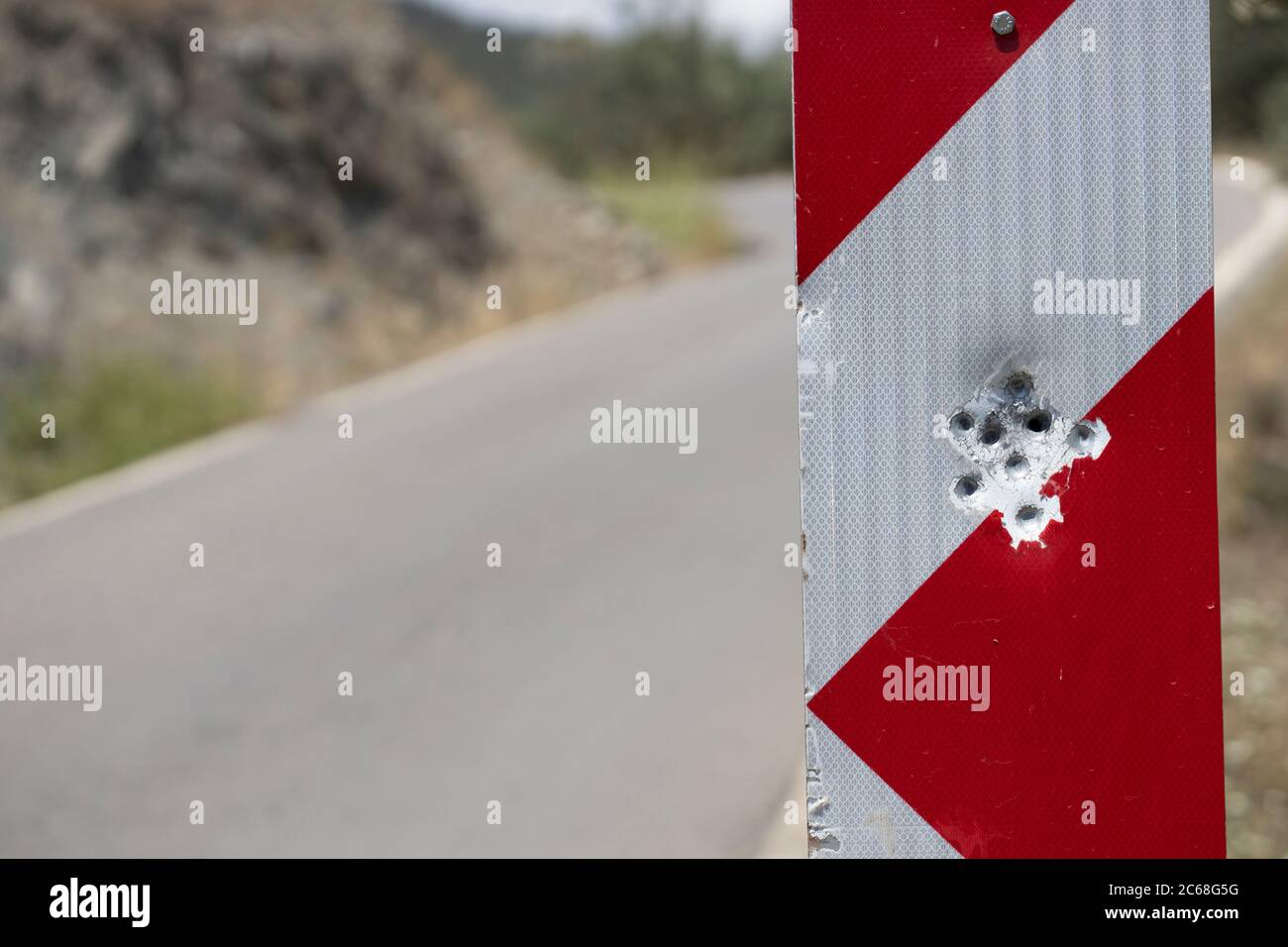 Red road traffic sign full of bullet holes. Close up Stock Photo - Alamy