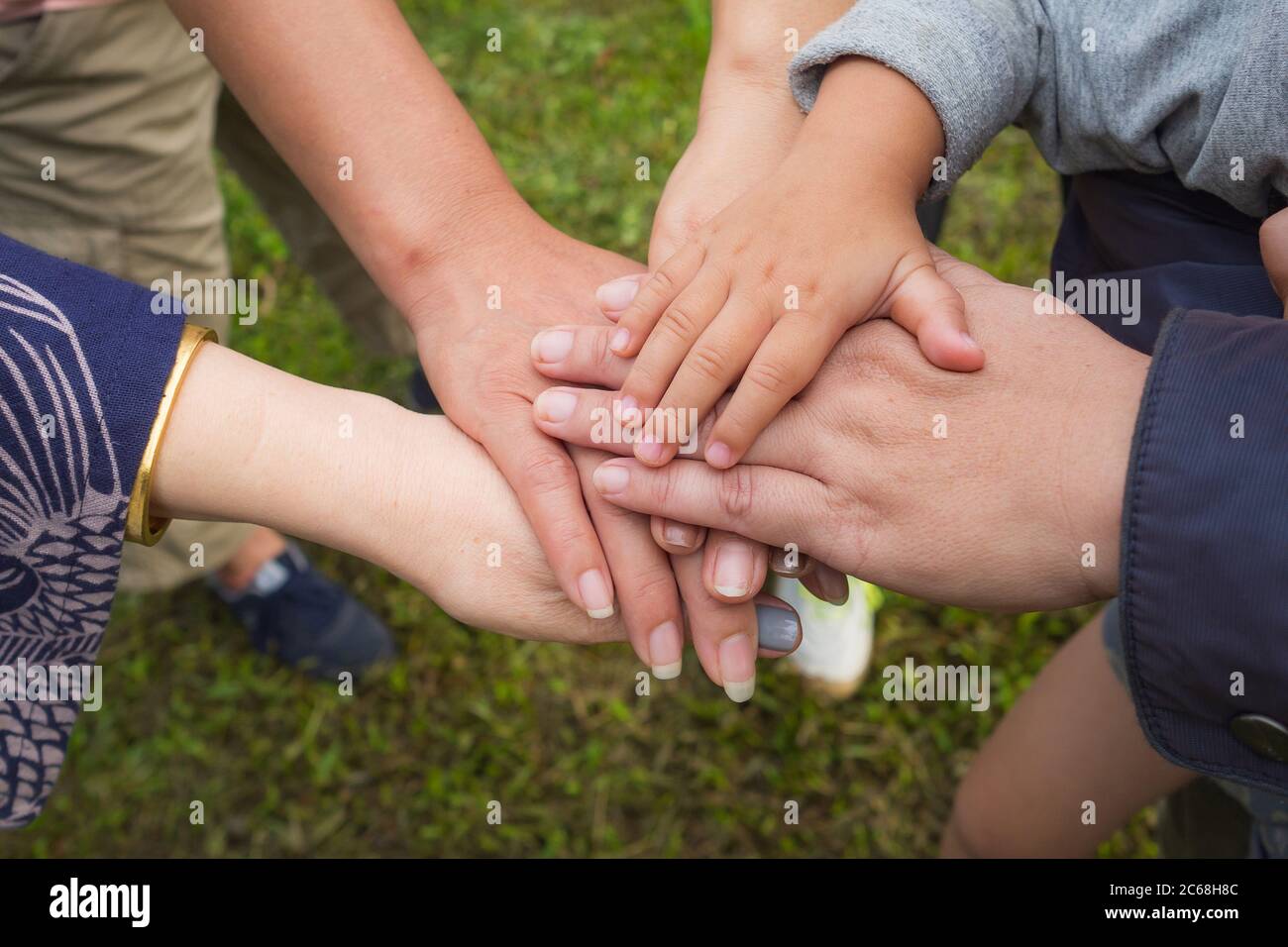 Top view of young people and kid putting their hands together. Family ...