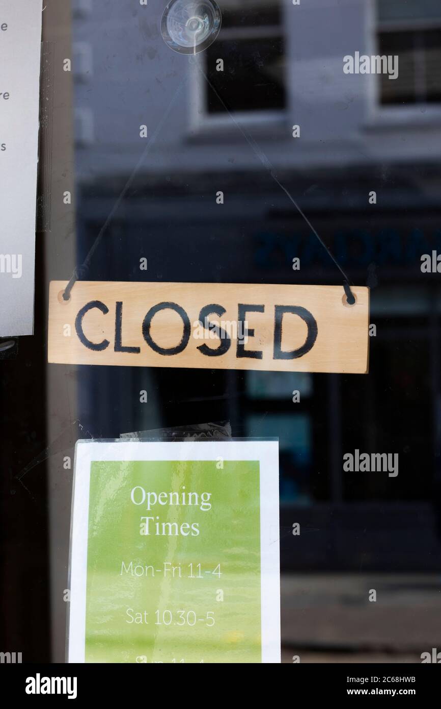 Hand written closed sign in retail shop door window with some ...