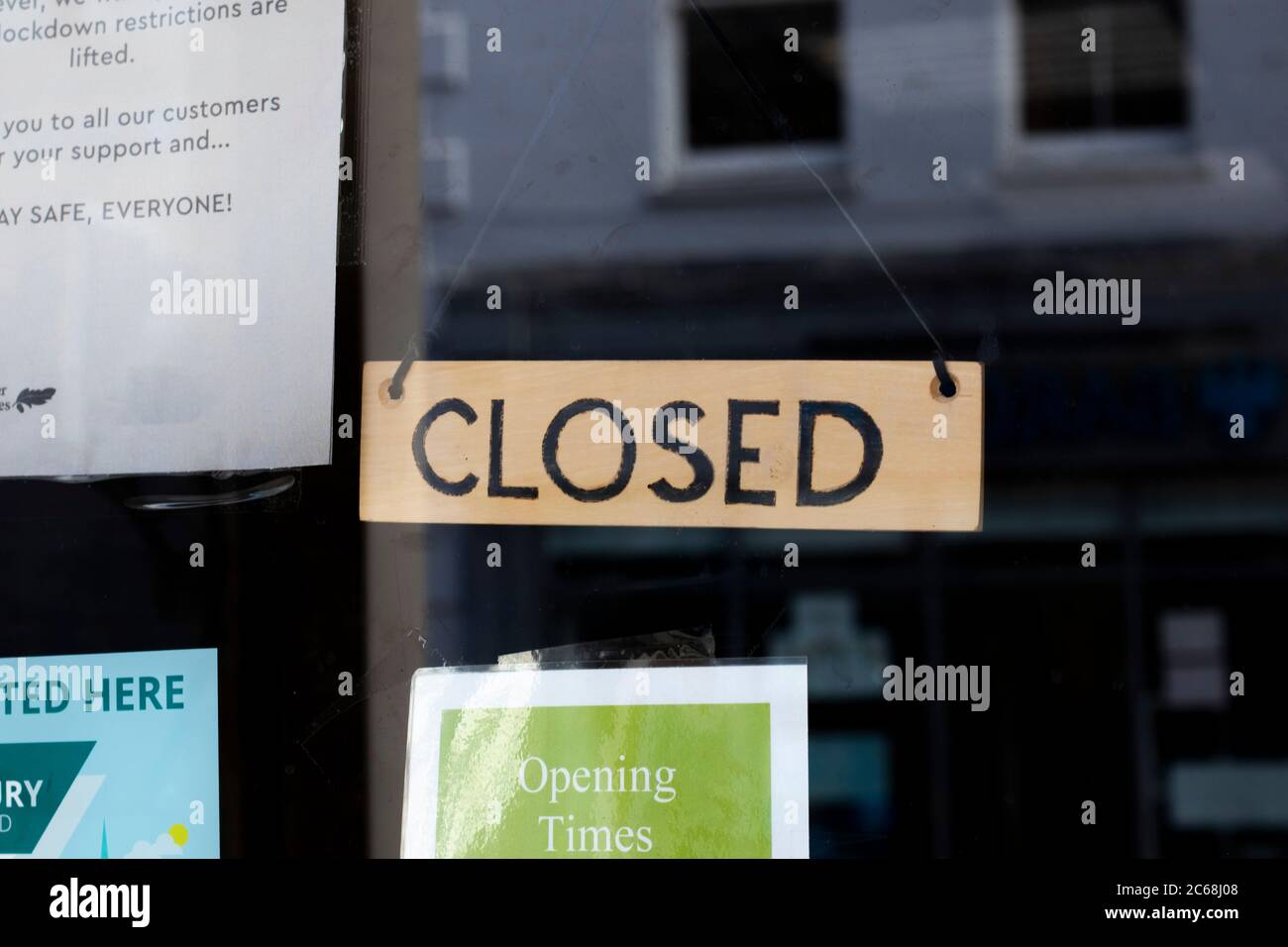 Hand written closed sign in retail shop door window with some ...