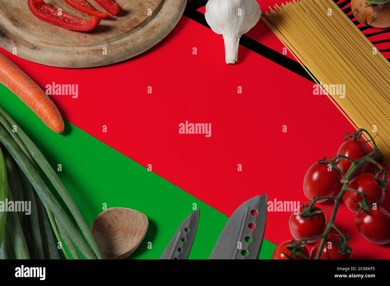Malawi flag on fresh vegetables and knife concept wooden table. Cooking ...