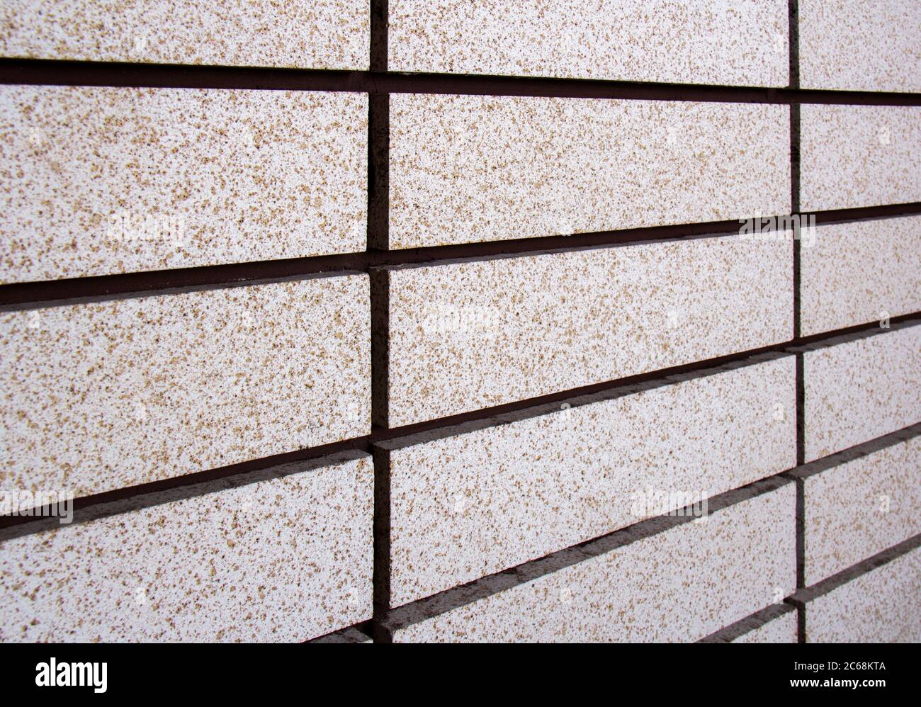 View from a side angle of bricks side by side - on a wall. The front of ...