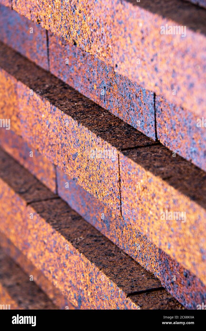 View from a side angle of bricks side by side - on a wall. The front of ...