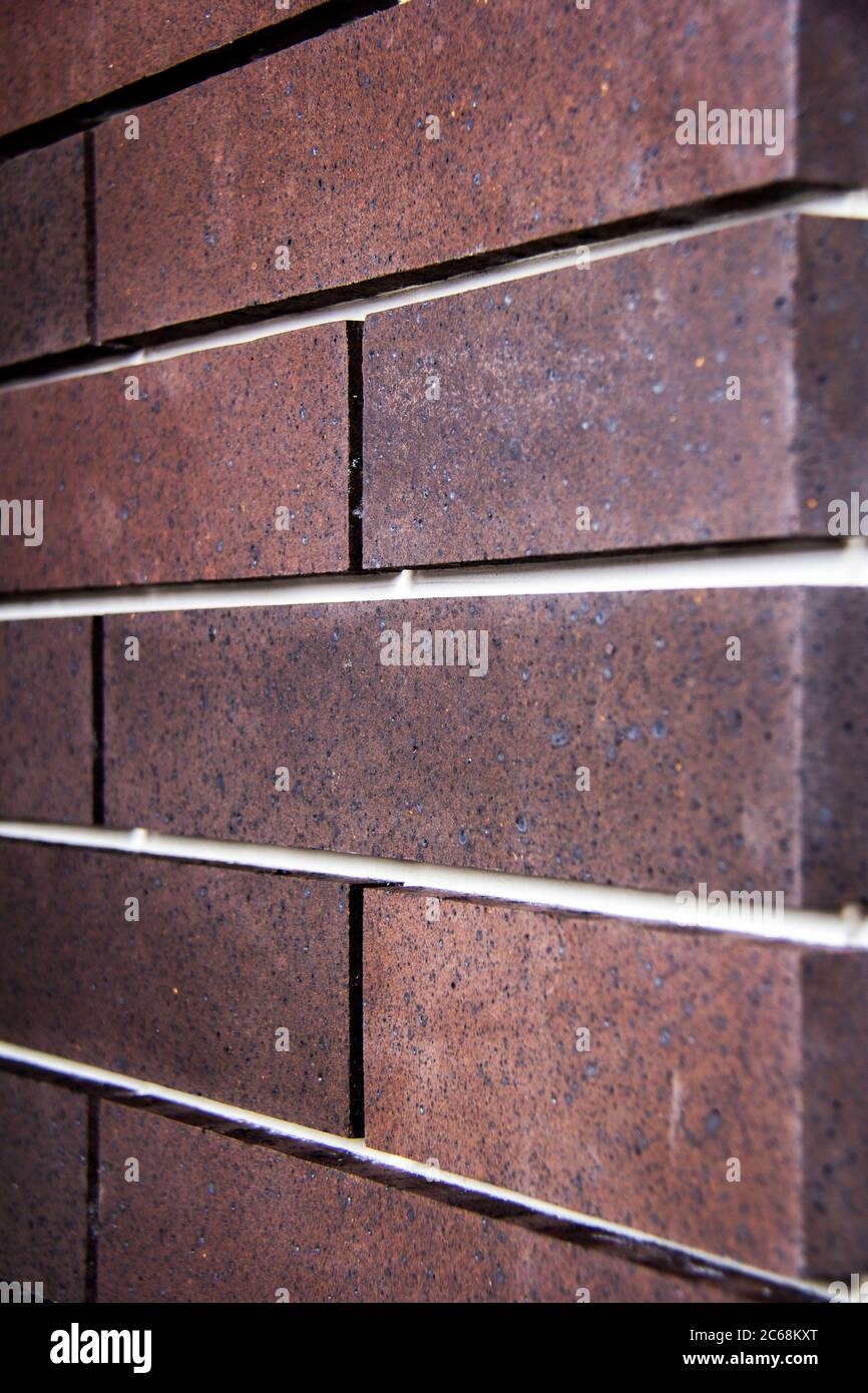 View from a side angle of bricks side by side - on a wall. The front of ...