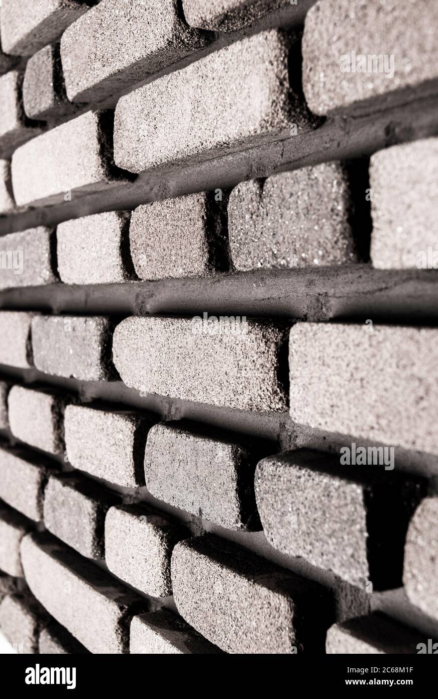 View from a side angle of bricks side by side - on a wall. The front of ...