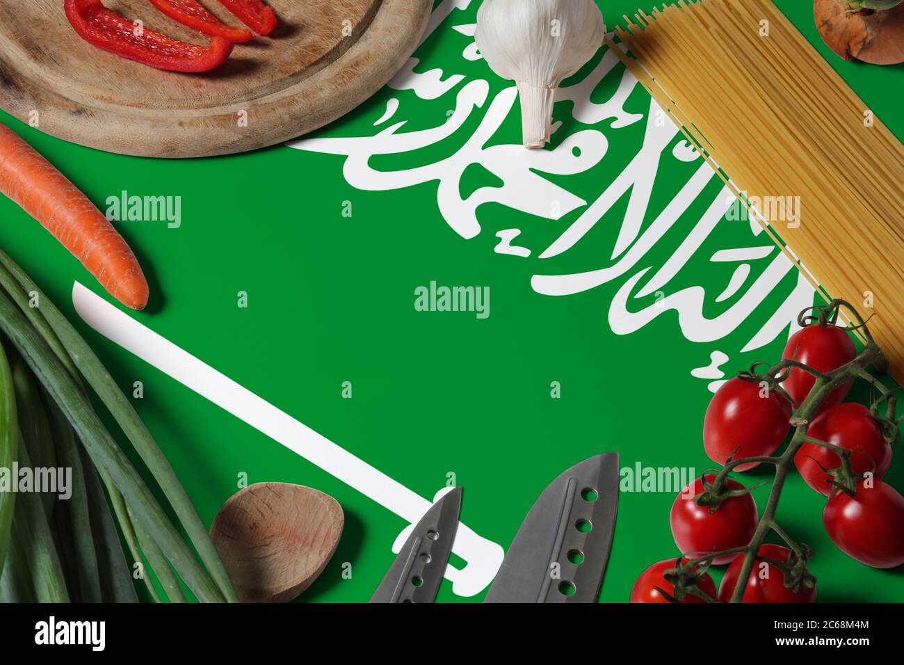Saudi Arabia flag on fresh vegetables and knife concept wooden table ...