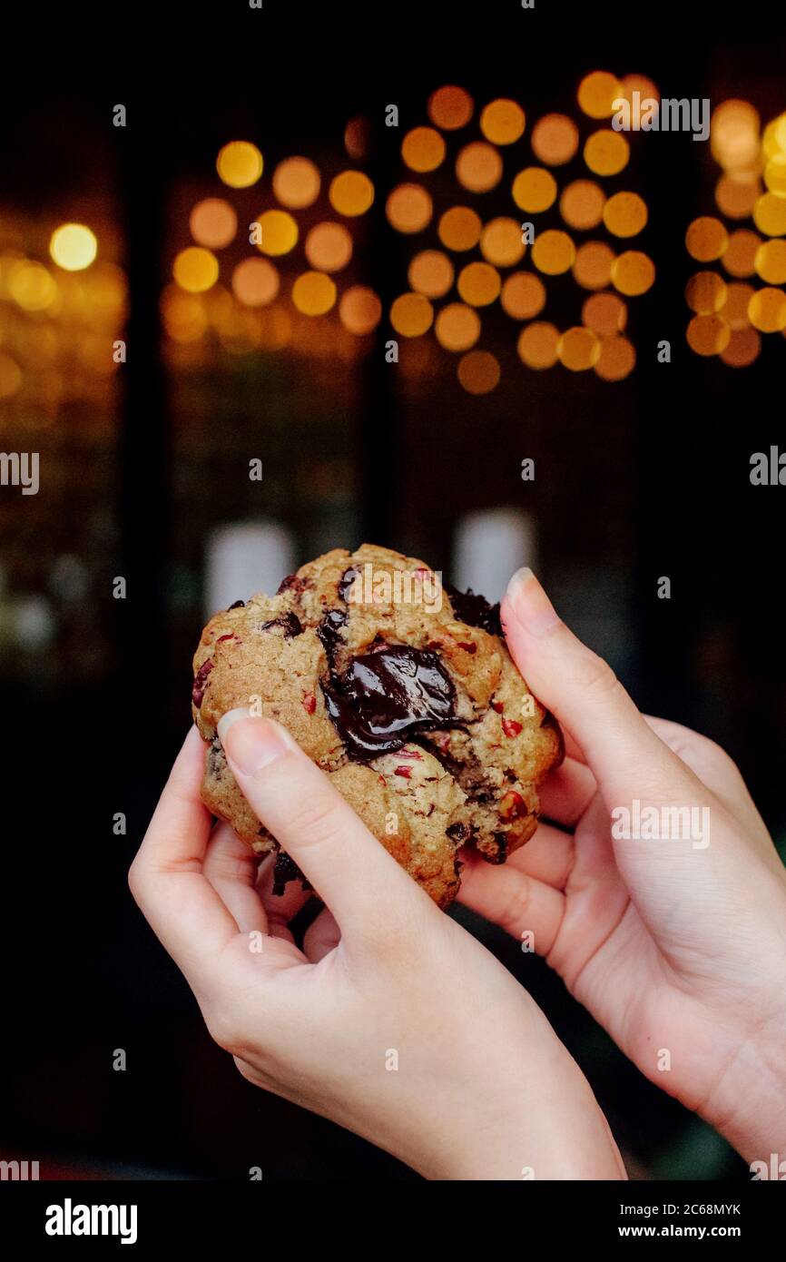 Beautiful hands to break chocolate berry cookie Stock Photo - Alamy