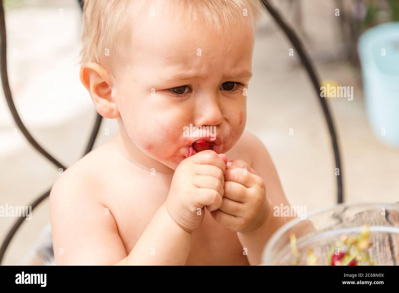 Cute happy boy eating sweet cherry, outdoor in garden Stock Photo - Alamy
