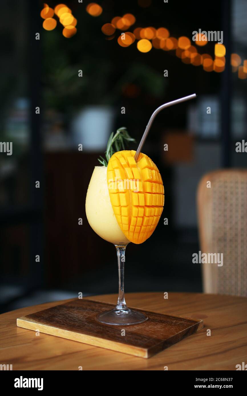 Mango smoothie in tall wine glass with mango cut in stripes Stock Photo ...
