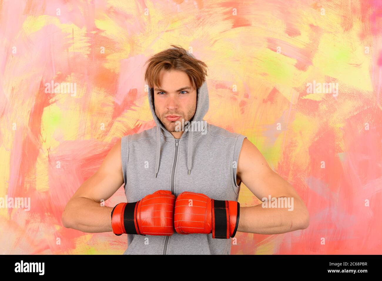 Man with messy hair on colorful background. Guy in grey sleeveless ...