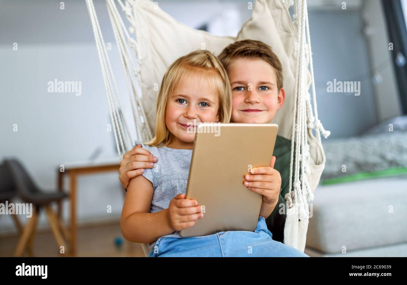 Childhood, technology and family concept. Little kids playing with ...